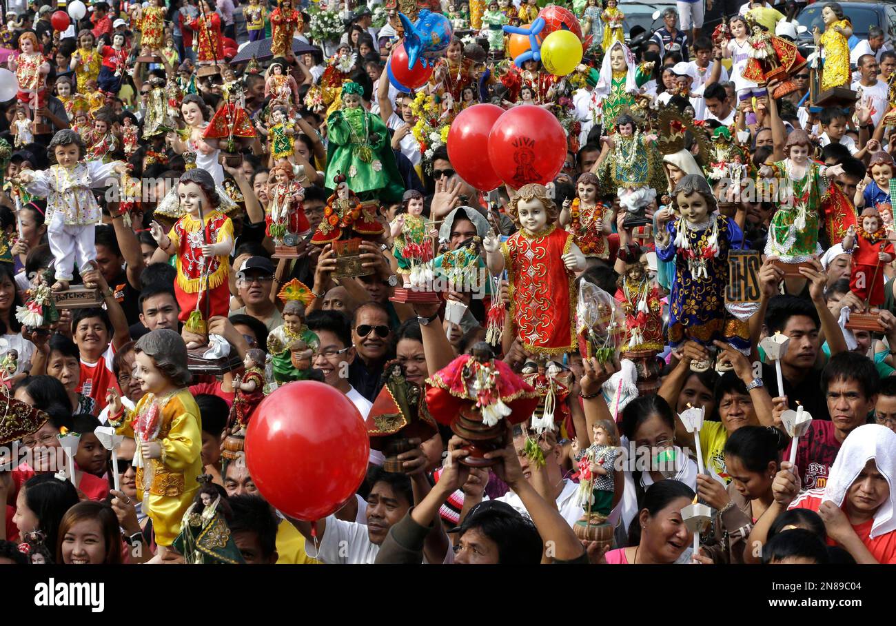 Hundreds of Roman Catholic devotees raise their images of the Infant ...