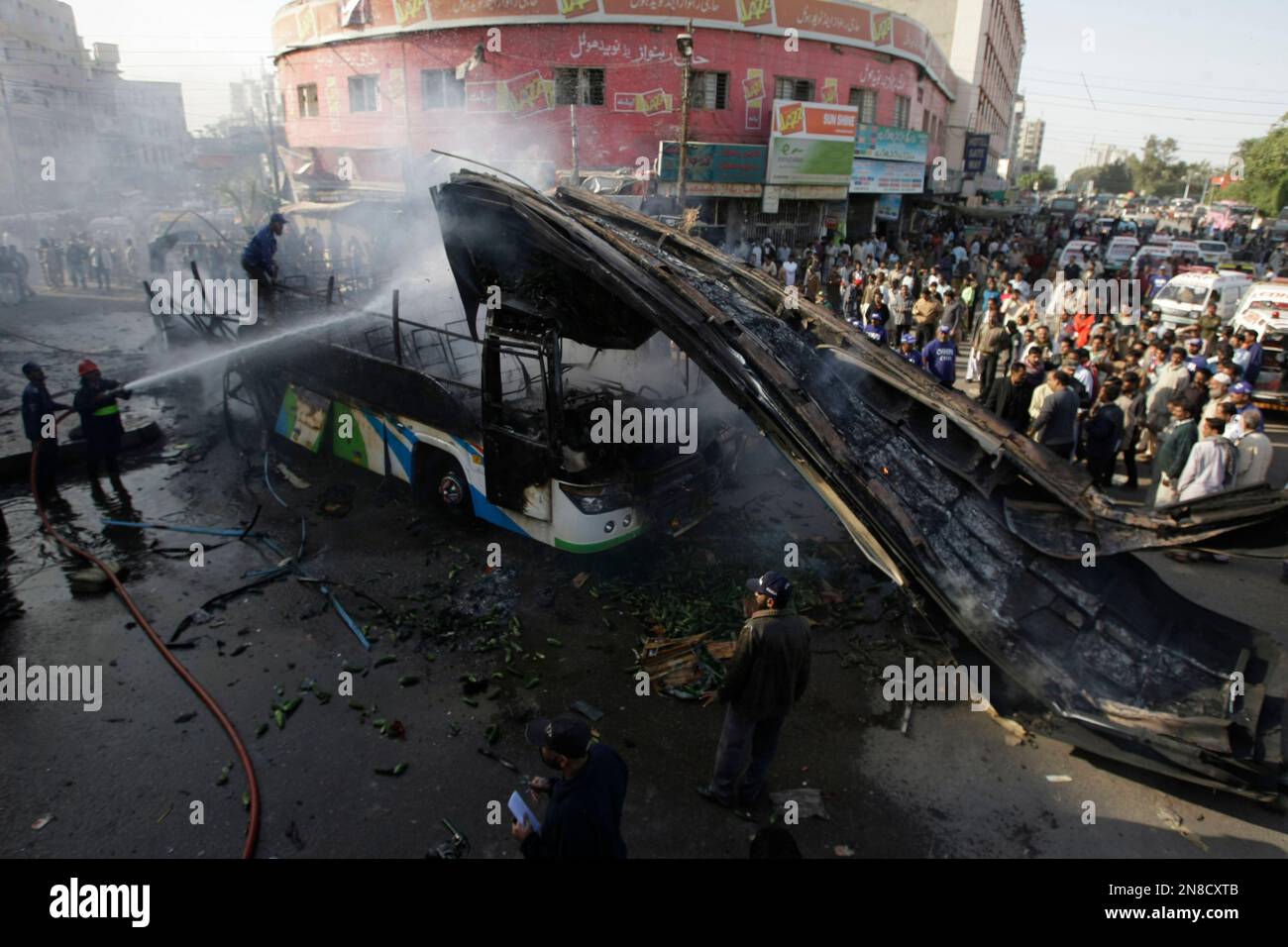 Pakistani firemen try to extinguish a fire following a blast in Karachi ...