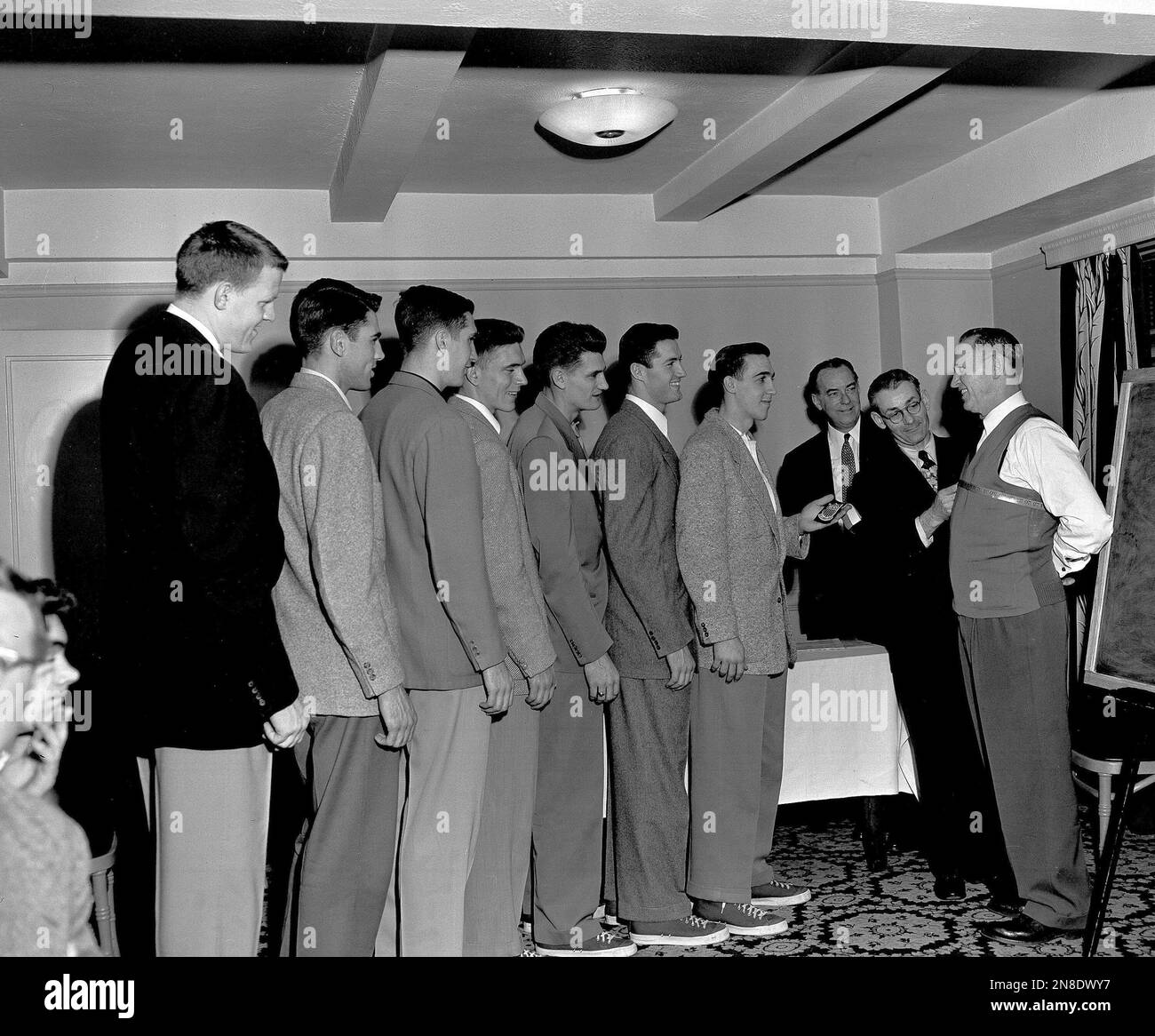 Seven members of the University of Kansas basketball team wait their ...