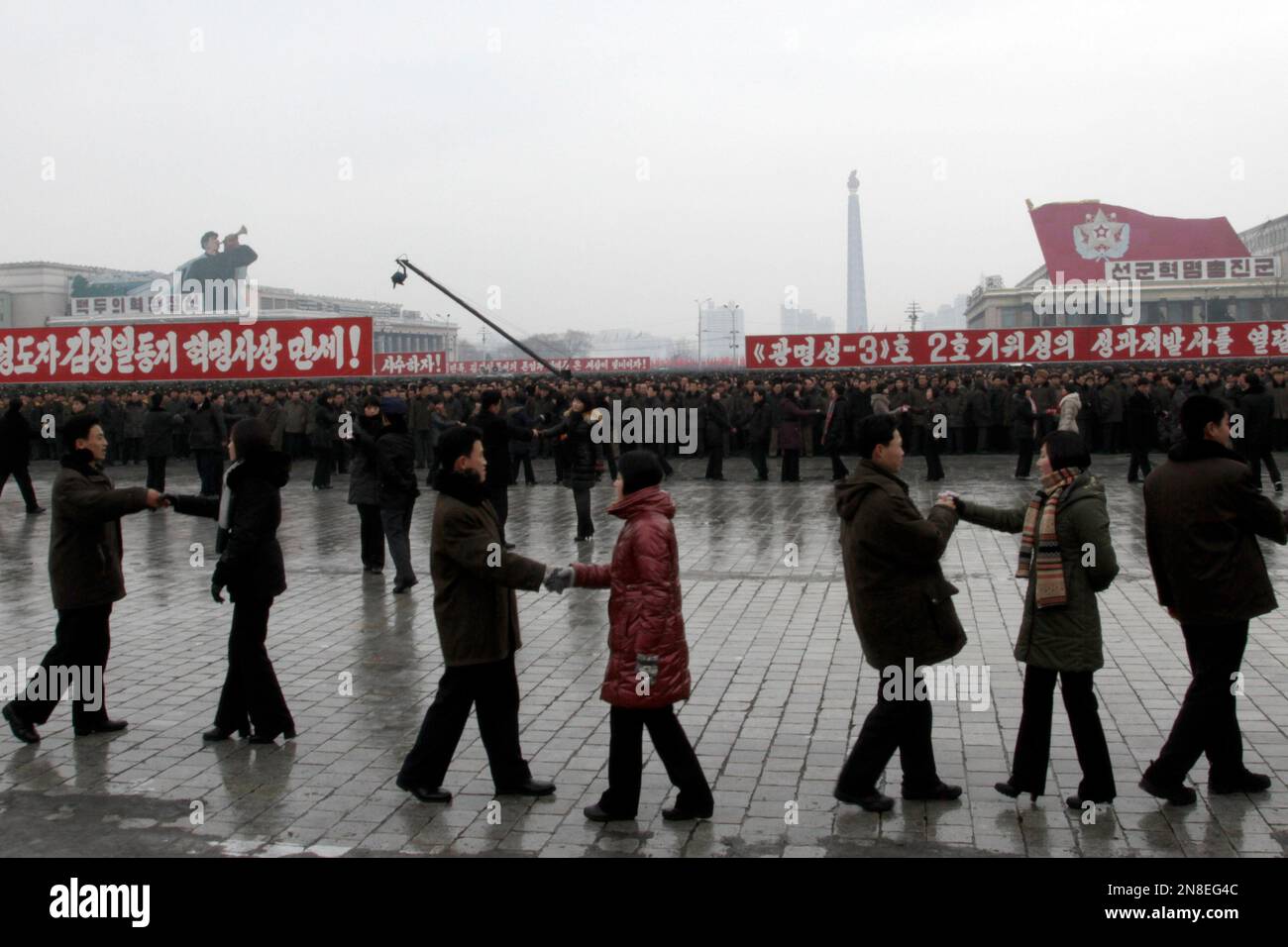 North Koreans dance near slogans from left which reads "Hurrah to the ...