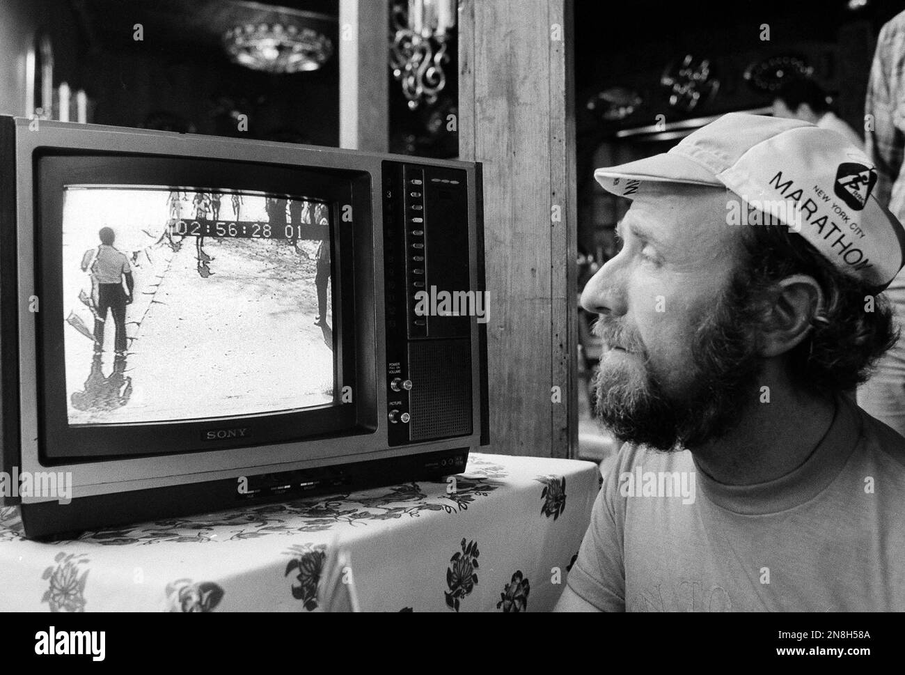 Fred Lebow, president of the New York Roadrunners Club, gazes at a TV ...