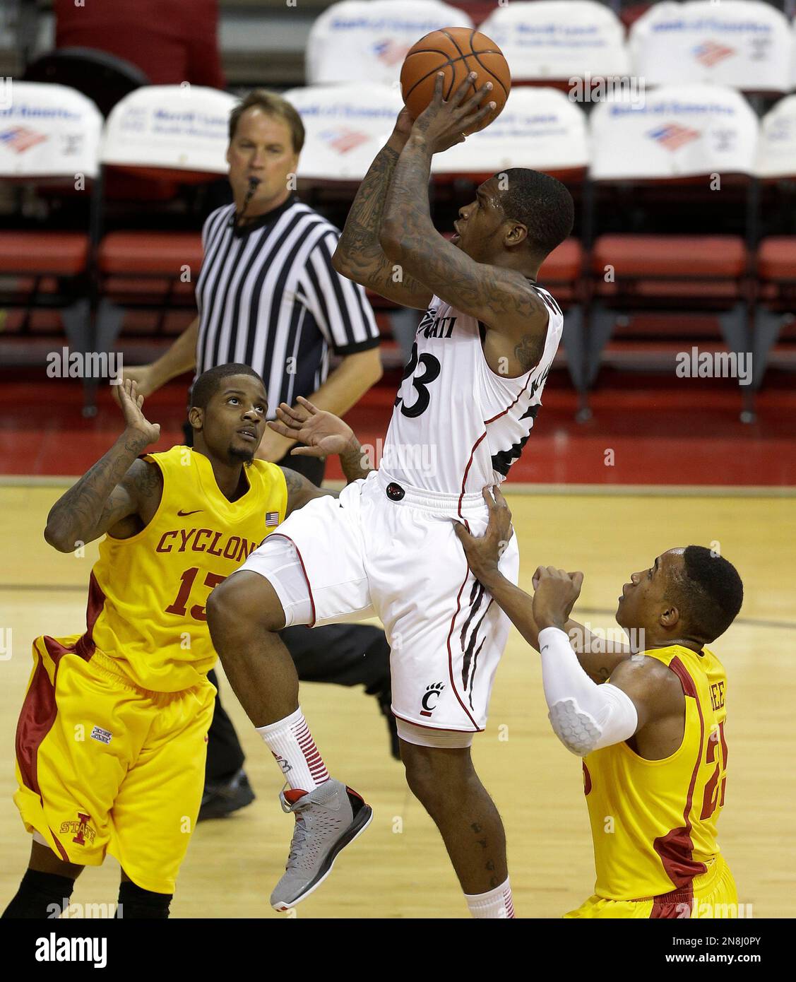 Cincinnati's Sean Kilpatrick, center, drives the lane for a shot ...
