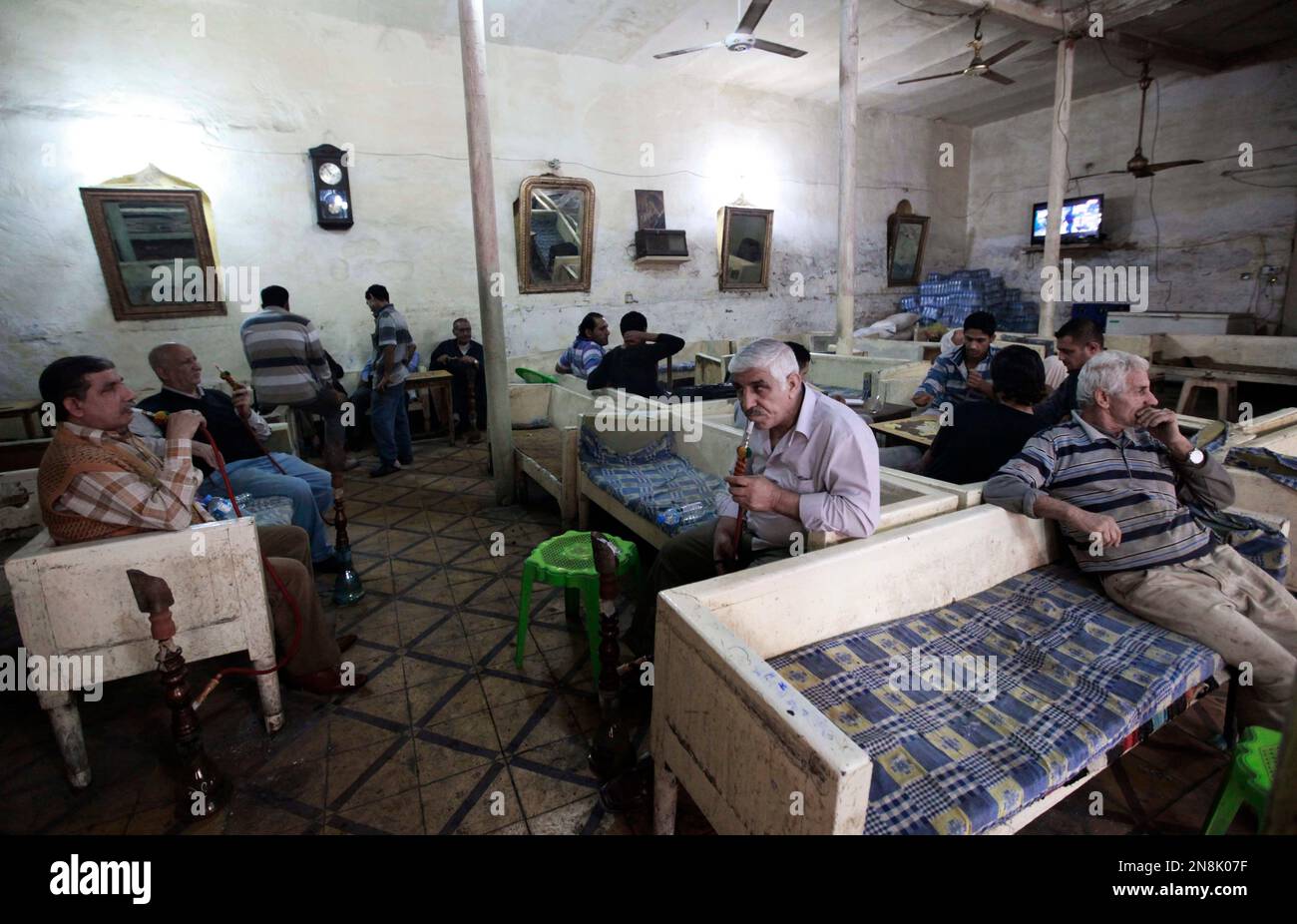 Patrons sit in a cafe at al-Rasheed street, the oldest street in ...