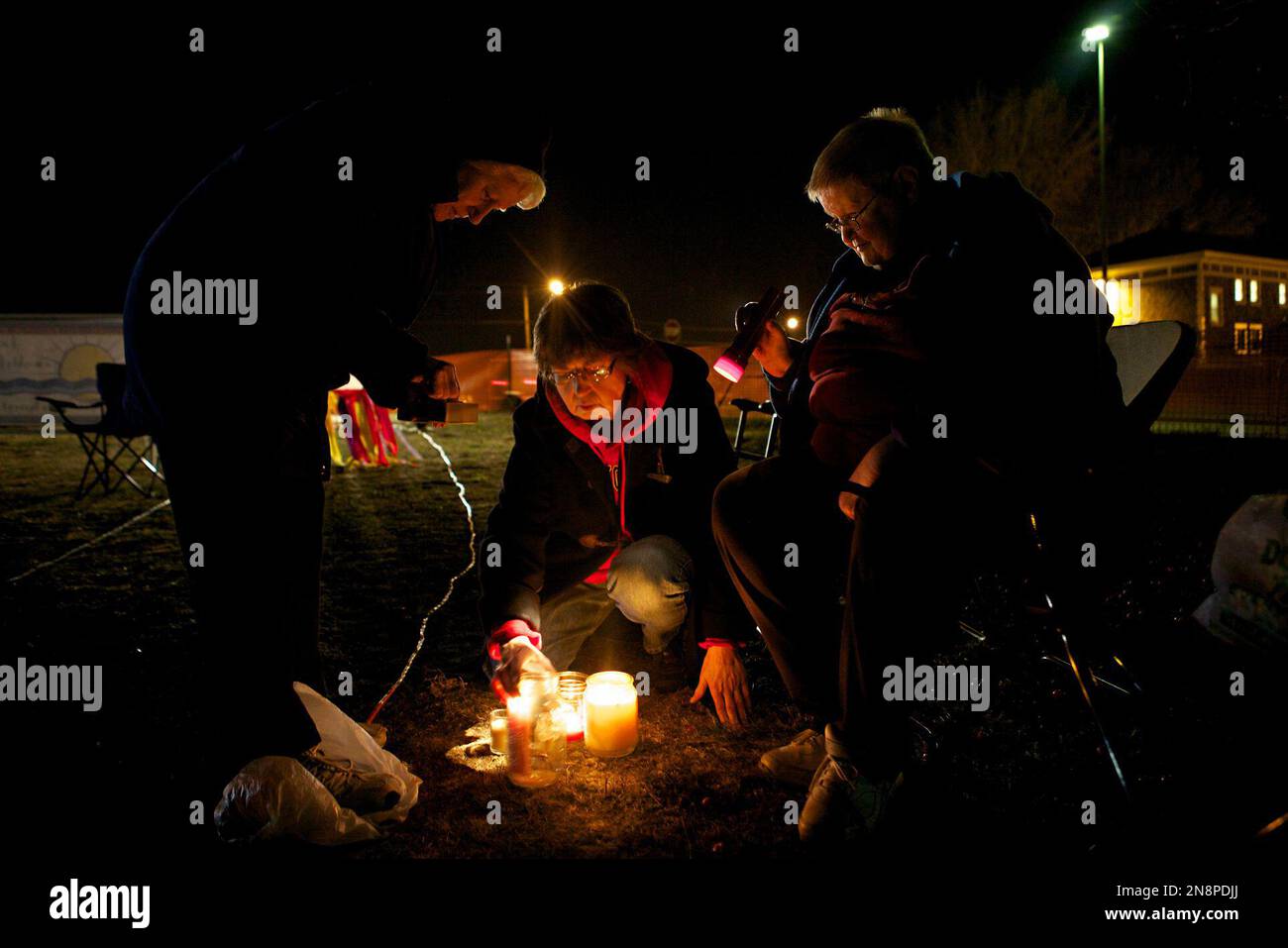 Leona Wieland, 65, of Sioux Falls, center, lights candles in protest ...