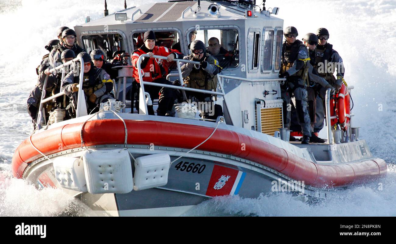 A U.S. Coast Guard boat kicks up a spray of sea water as it approaches ...