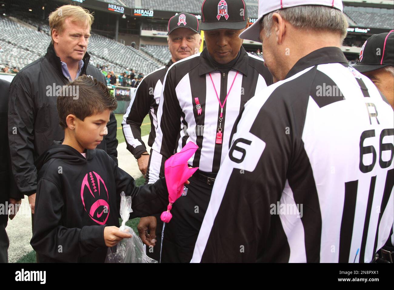 NFL Commissioner Roger Goodell, left, watches as Dante Cano, 11, second ...