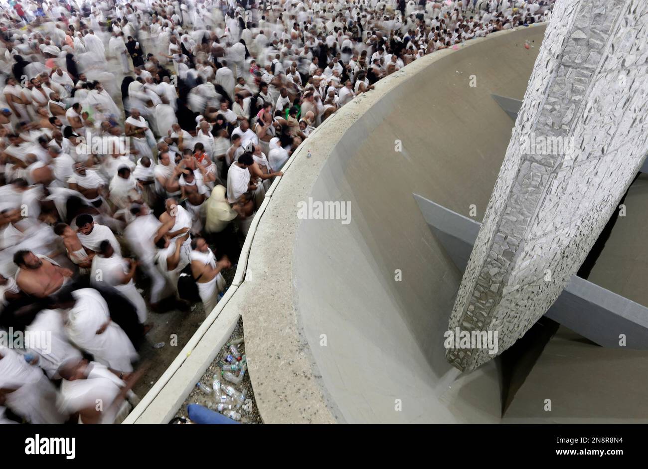 Muslim pilgrims cast stones at a pillar, symbolizing the stoning of ...
