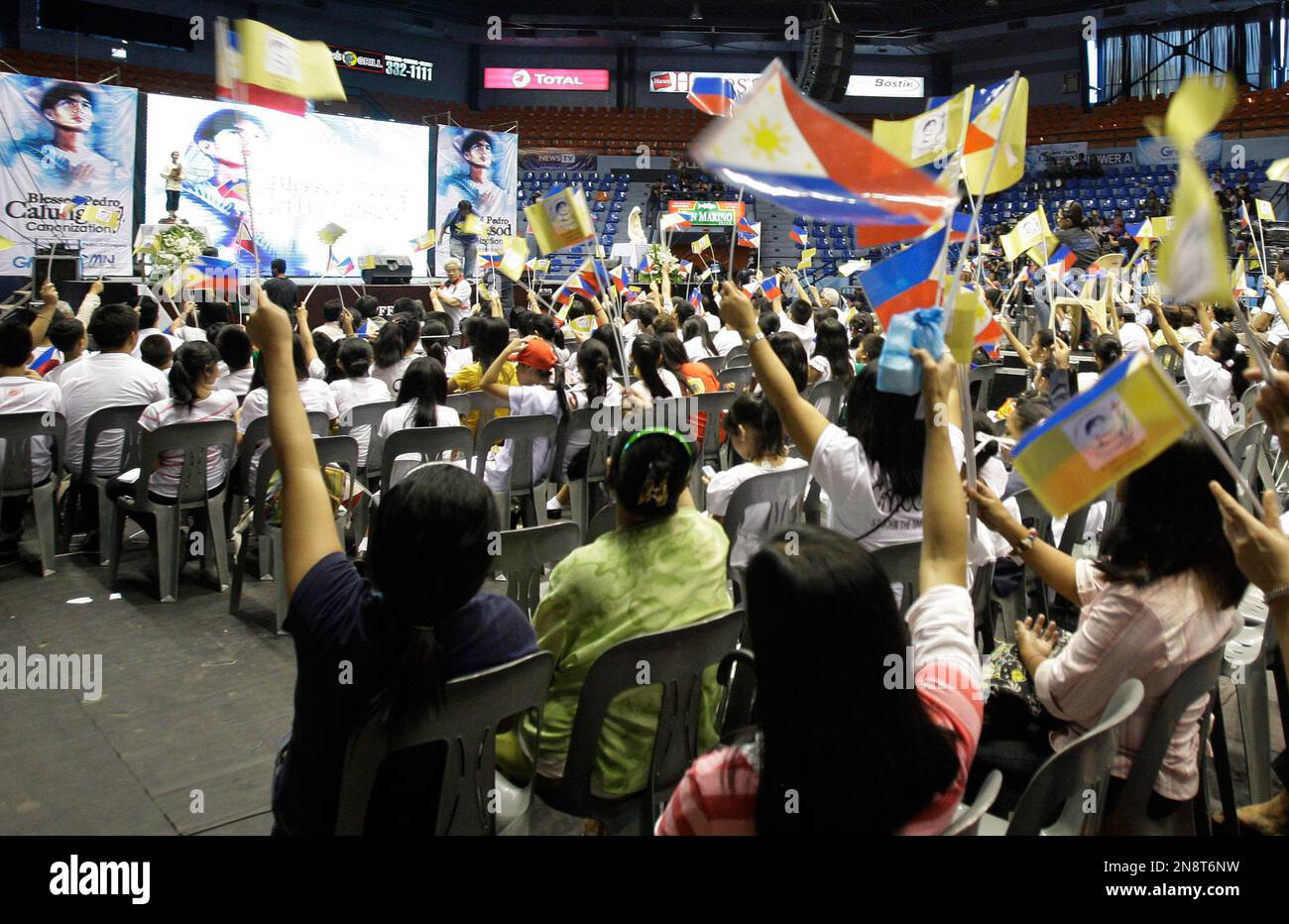 A crowd cheers as they watch the canonization of Filipino saint Pedro ...