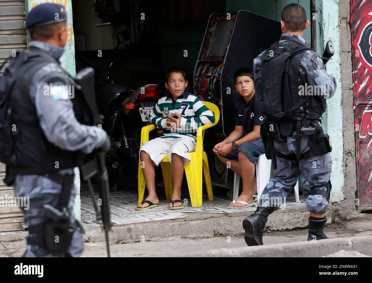 Children look to police officers during an operation to install a ...