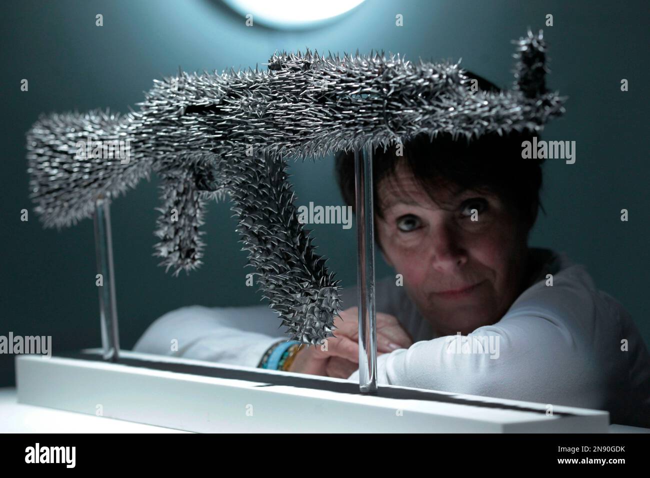 British artist Nancy Fouts poses by her interpretation of an AK-47 ...