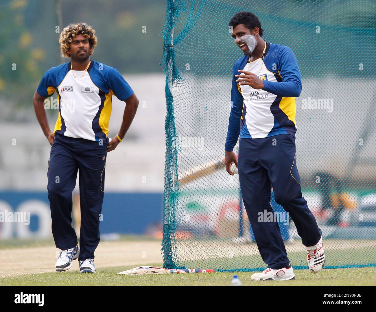 Sri Lankan cricketer Lasith Malinga, left, watches as teammate Thisara Perera reacts in pain ...