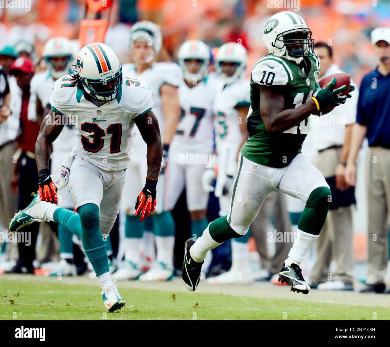 New York Jets wide receiver Santonio Holmes (10) runs with the ball as ...