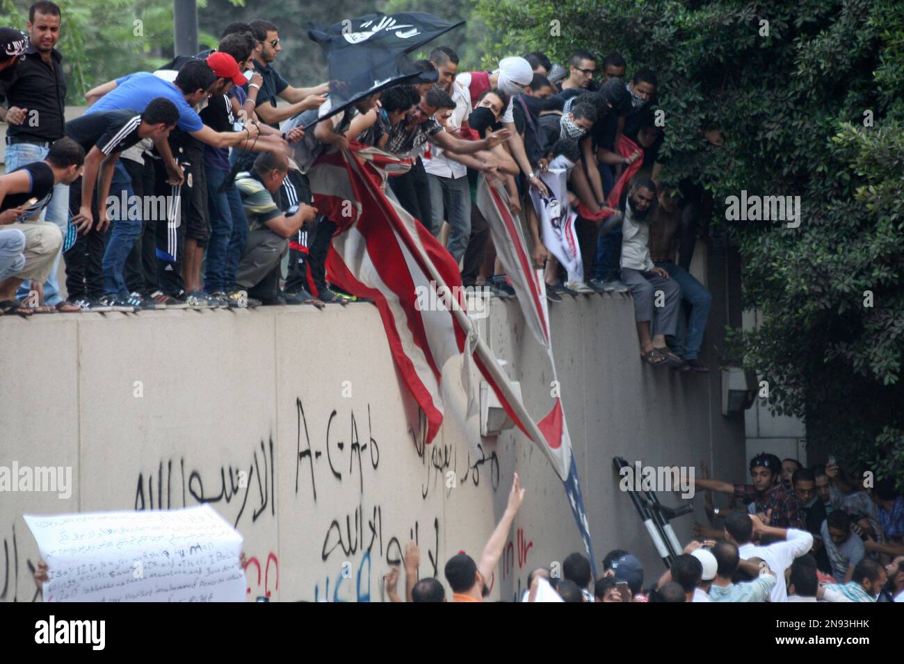 Protesters destroy an American flag pulled down from the U.S. embassy ...