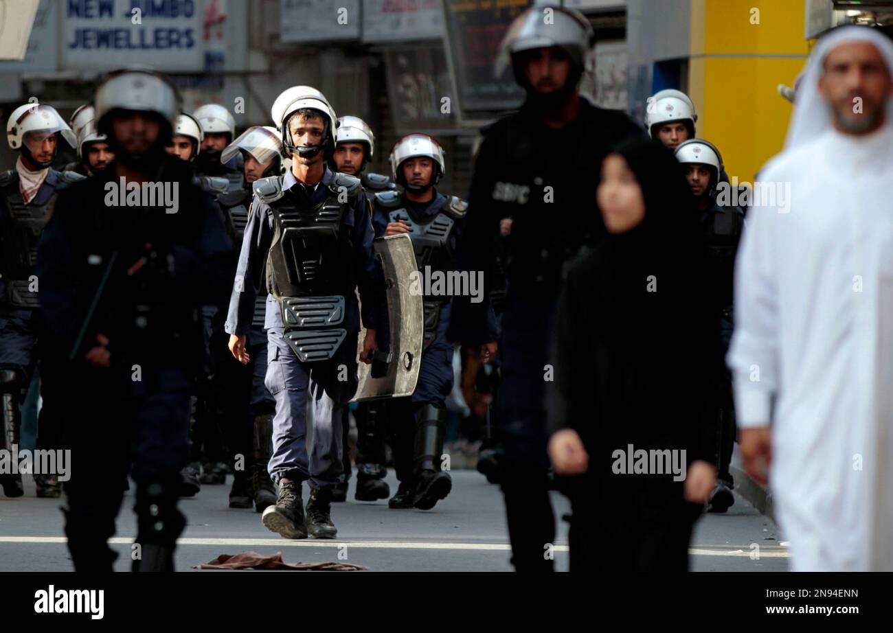 Riot police look for Bahraini anti-government protesters during street ...