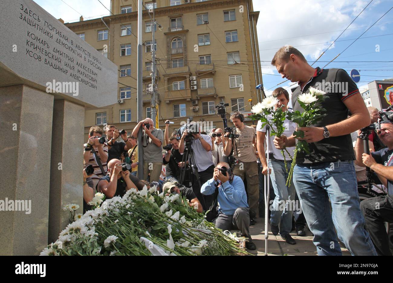 Russian opposition leader Alexei Navalny puts flowers at a memorial to ...