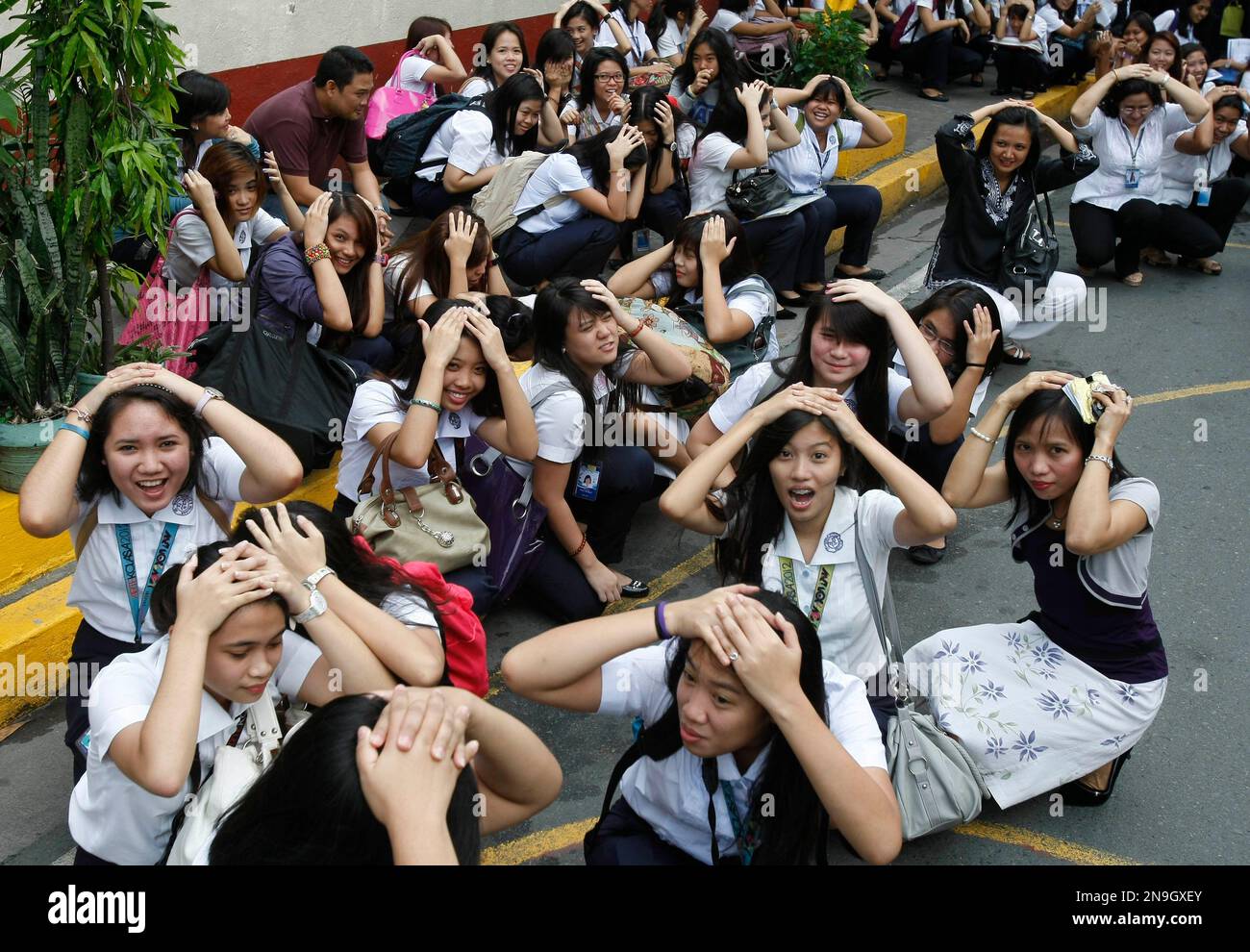 School children cover their heads as they evacuate from their school ...