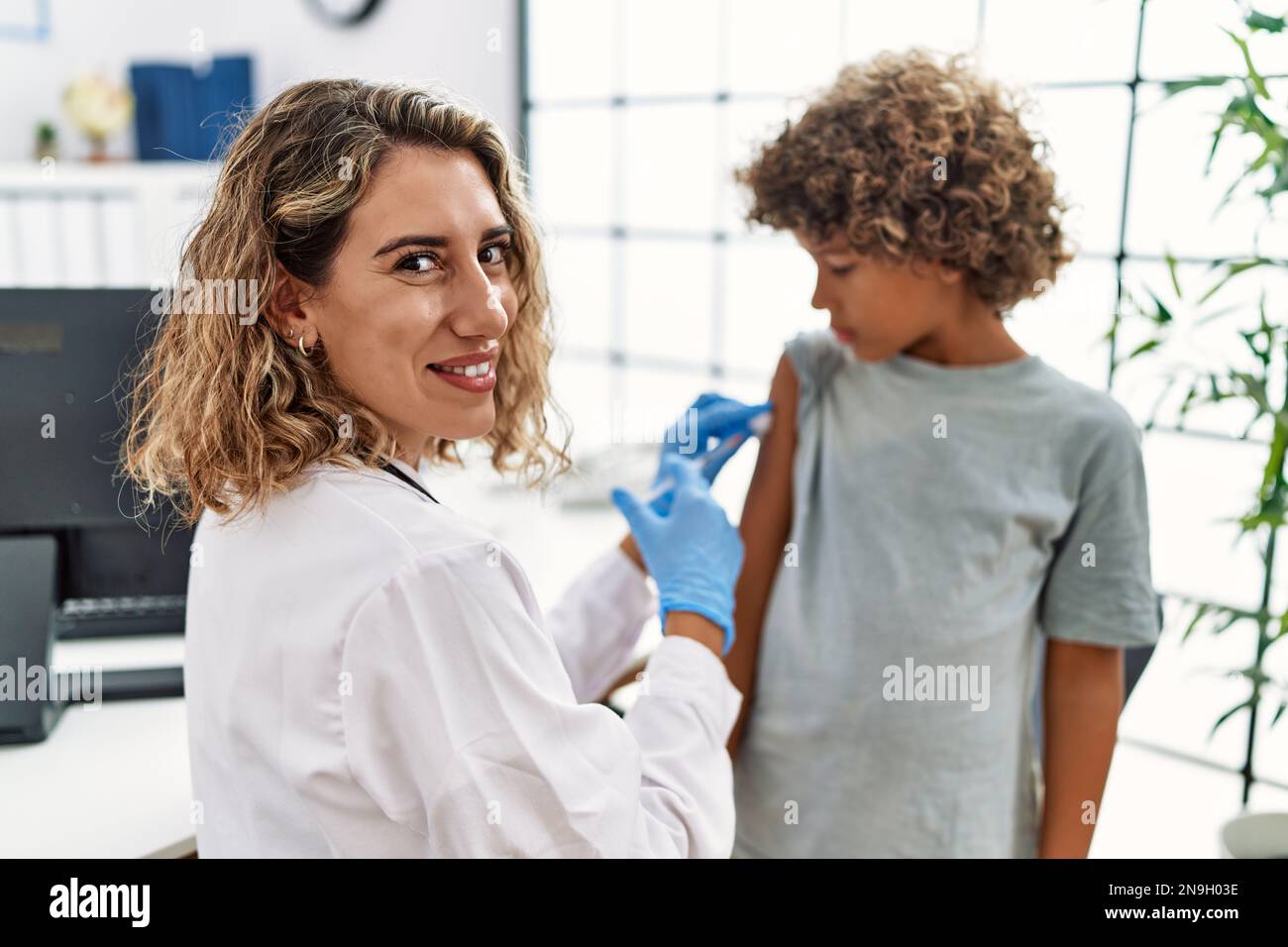 Mutter und Sohn tragen eine Arztzuniform, die das Kind in der Klinik ...