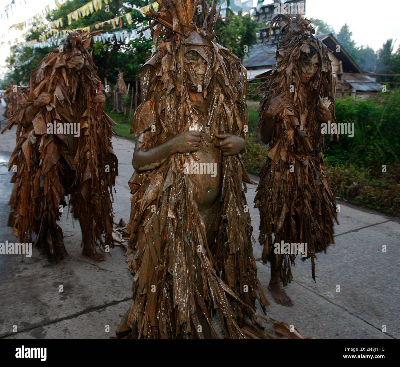 Filipino Catholic devotees, who soaked themselves in mud and wrapped in ...