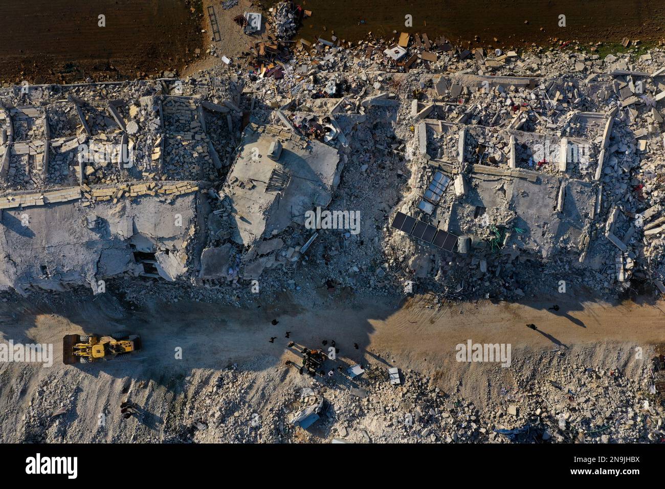 Rescue workers continue to clear rubble from collapsed houses in ...