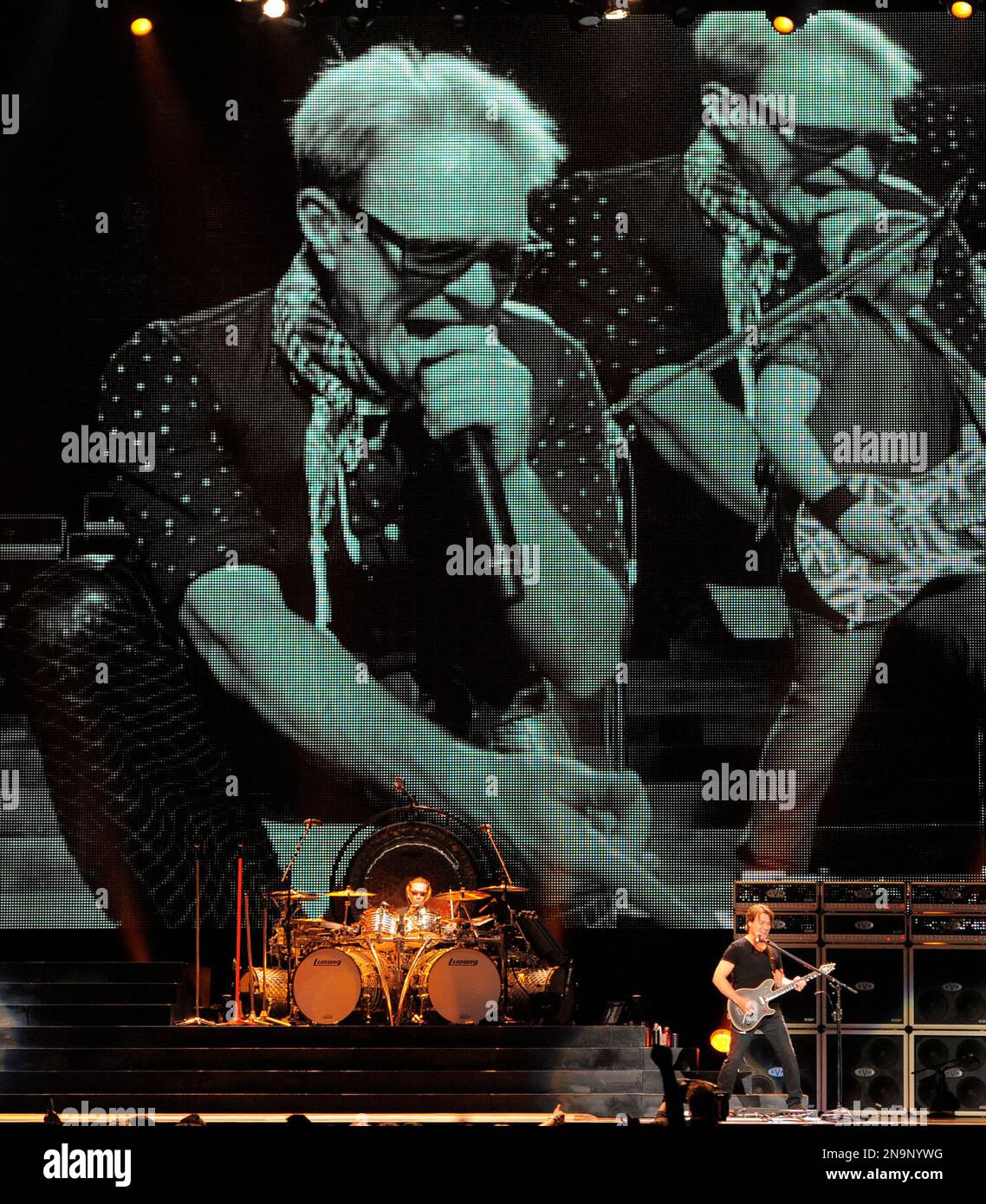 A video image of Van Halen lead singer David Lee Roth looms over ...