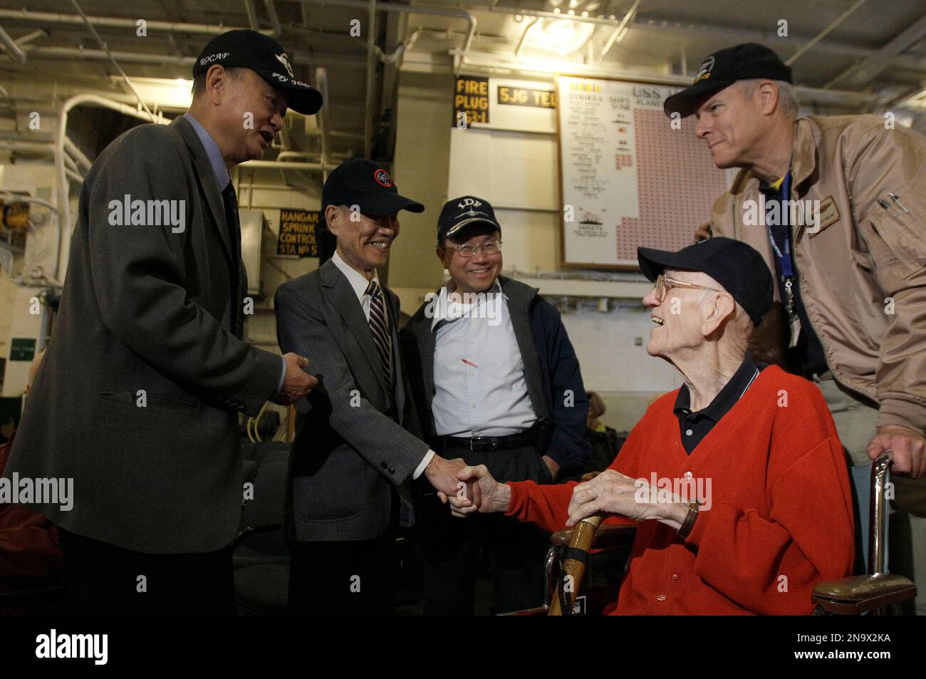 Major Thomas Griffin, seated at right, shakes hands with Lt. Col. Chu ...
