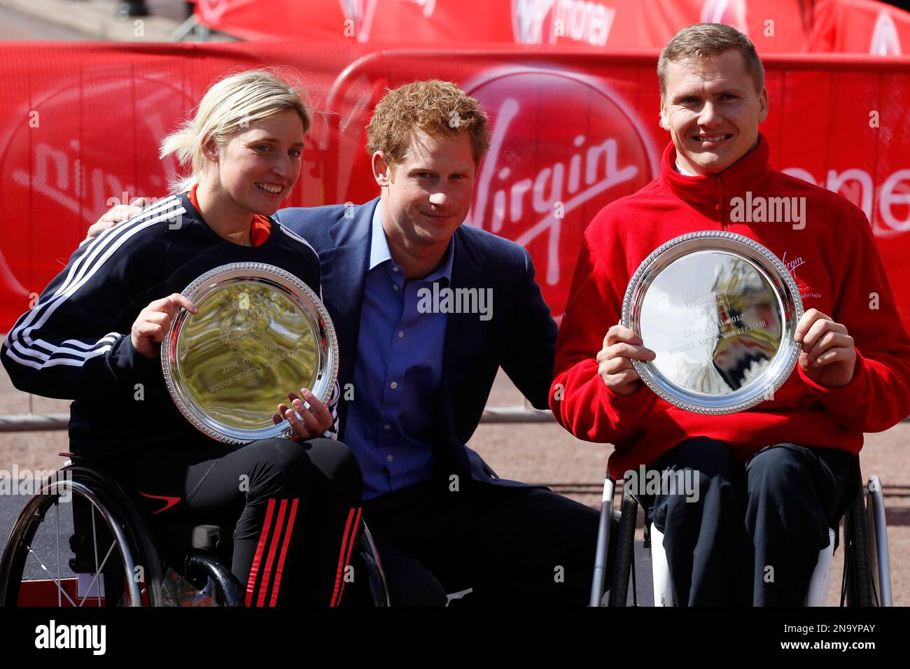 Britain's Prince Harry, center, poses with men and women wheelchair ...