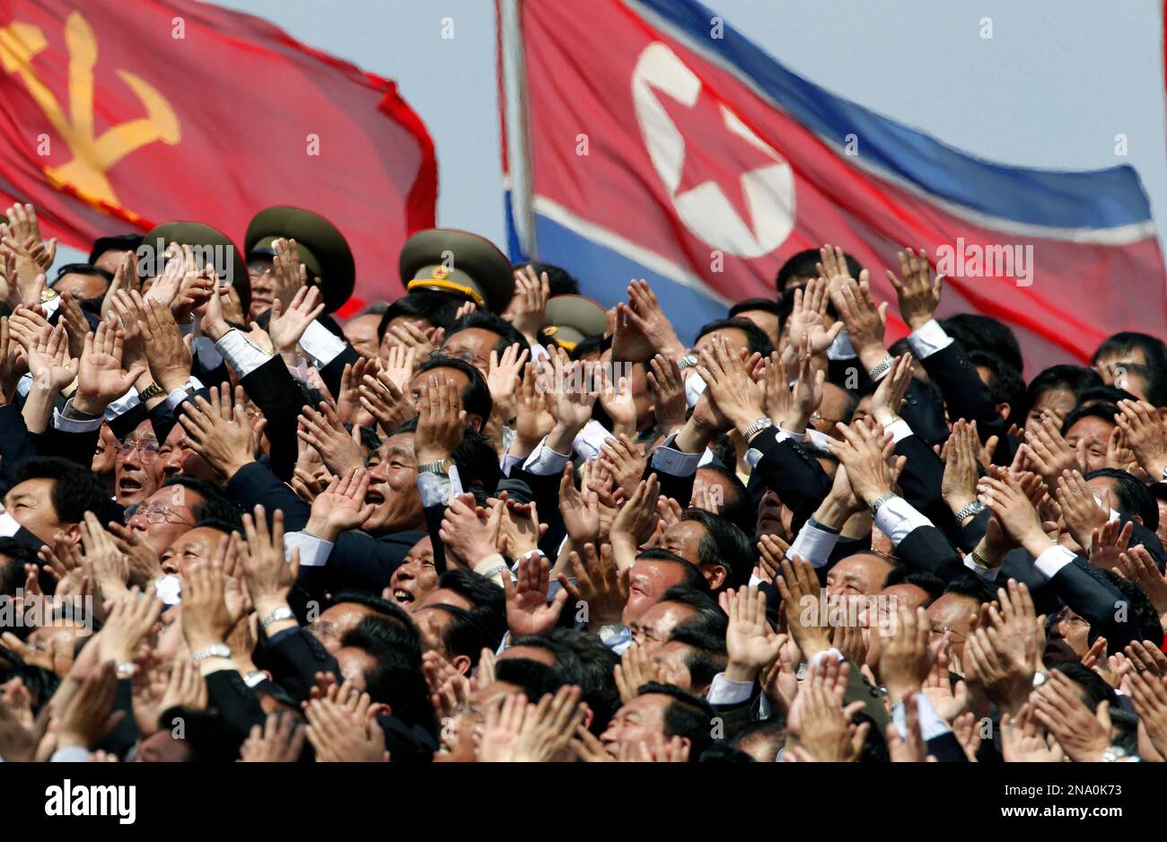 North Koreans wave and clap as North Korean leader Kim Jong Un, unseen ...