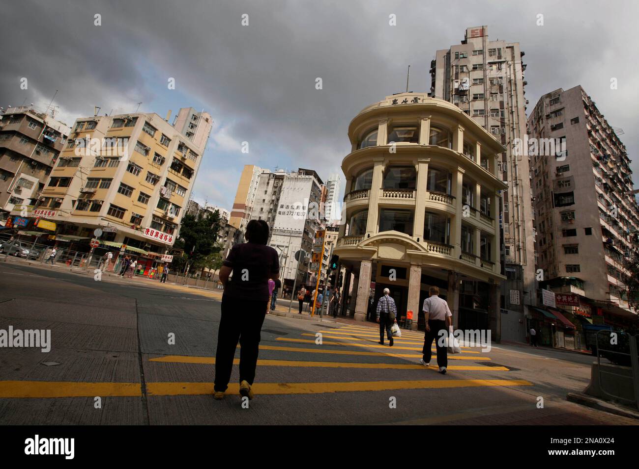 People walk near by 'Lui Seng Chun,' right, a heritage building ...