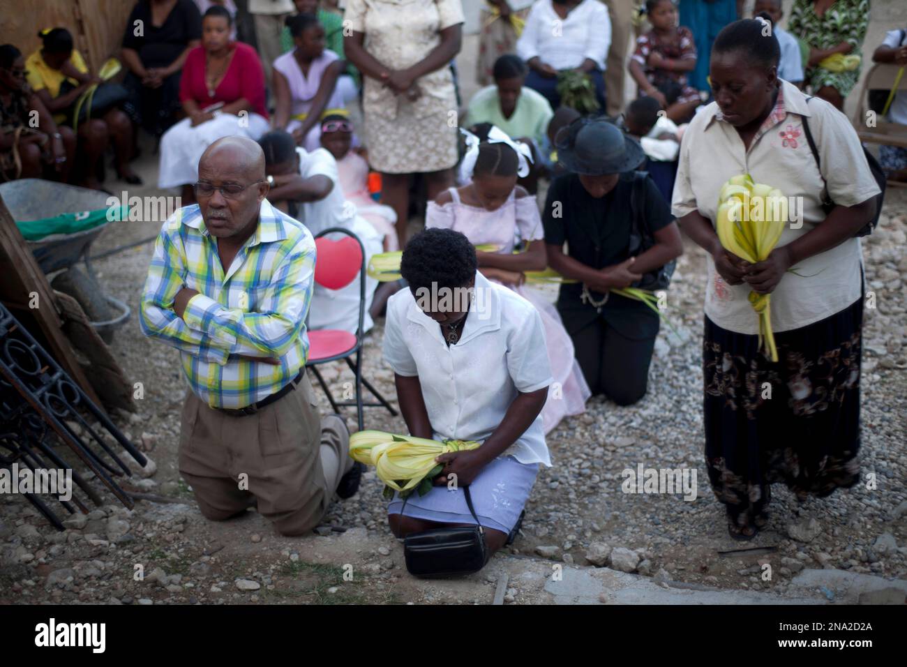 People hold palm fronds during an outdoor Palm Sunday Mass at the site ...