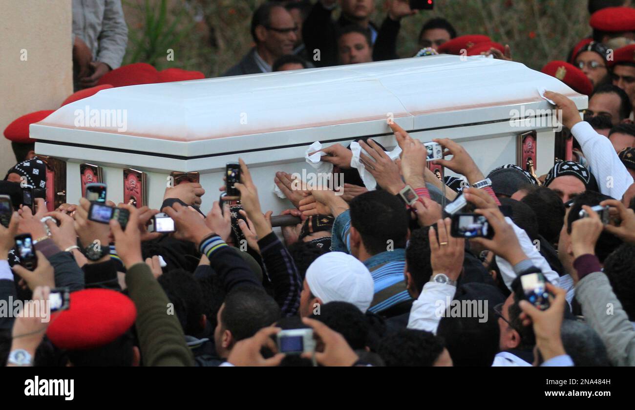 Mourners take pictures with their mobile phones of the coffin of Pope ...