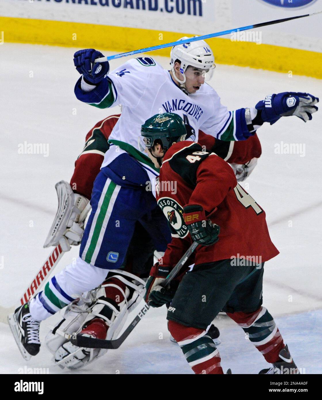 Vancouver Canucks' Alex Burrows, center, finds himself squeezed between ...