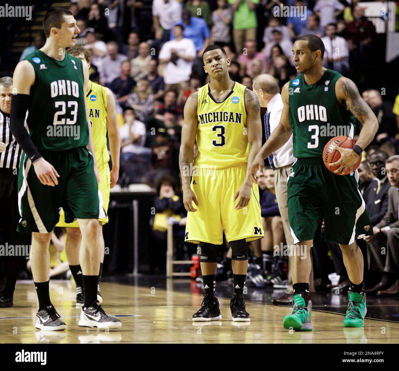 Michigan guard Trey Burke, center, looks on as Ohio guard Walter Offutt ...