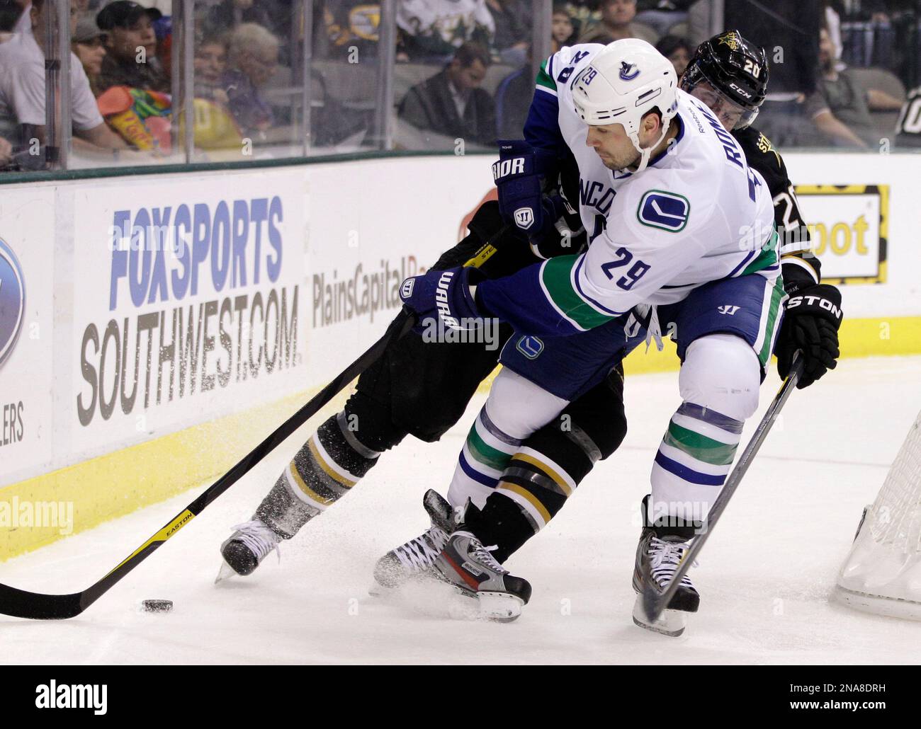 Vancouver Canucks' Aaron Rome (29) controls the puck behind the net as ...