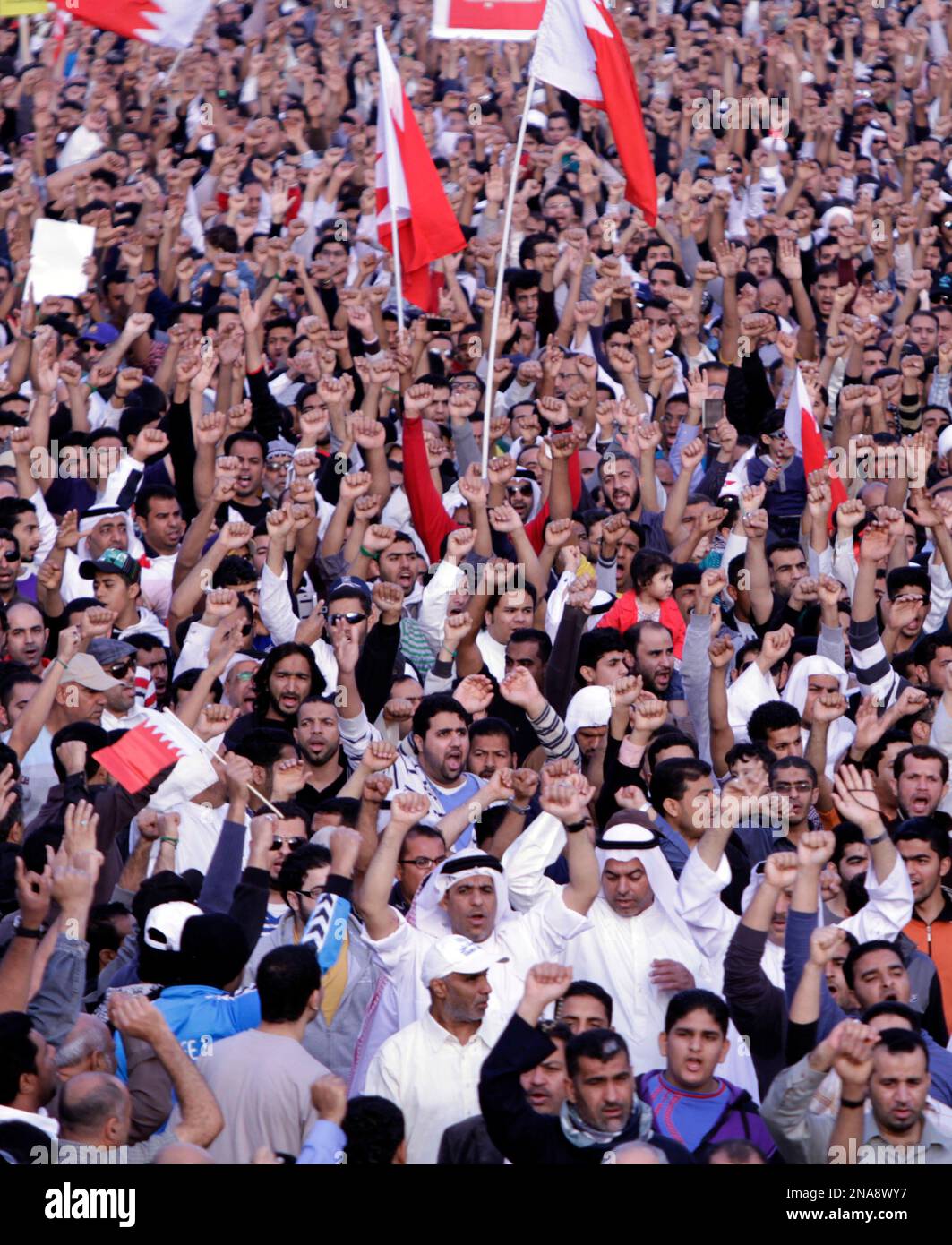 Anti-government protesters wave Bahraini flags and shout slogans ...