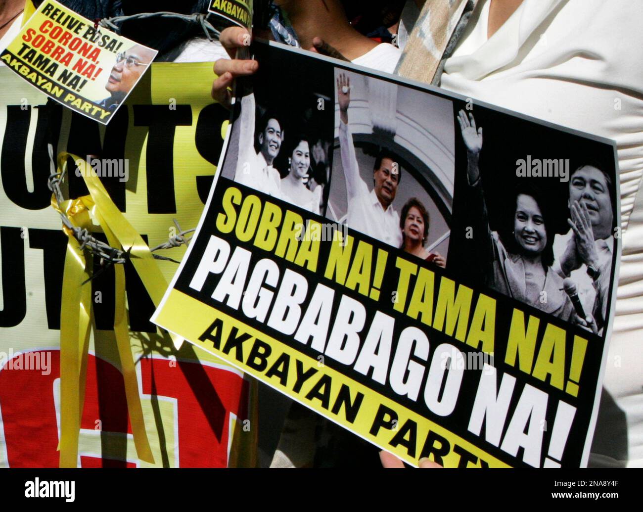A protester displays a poster showing pictures of the late strongman ...