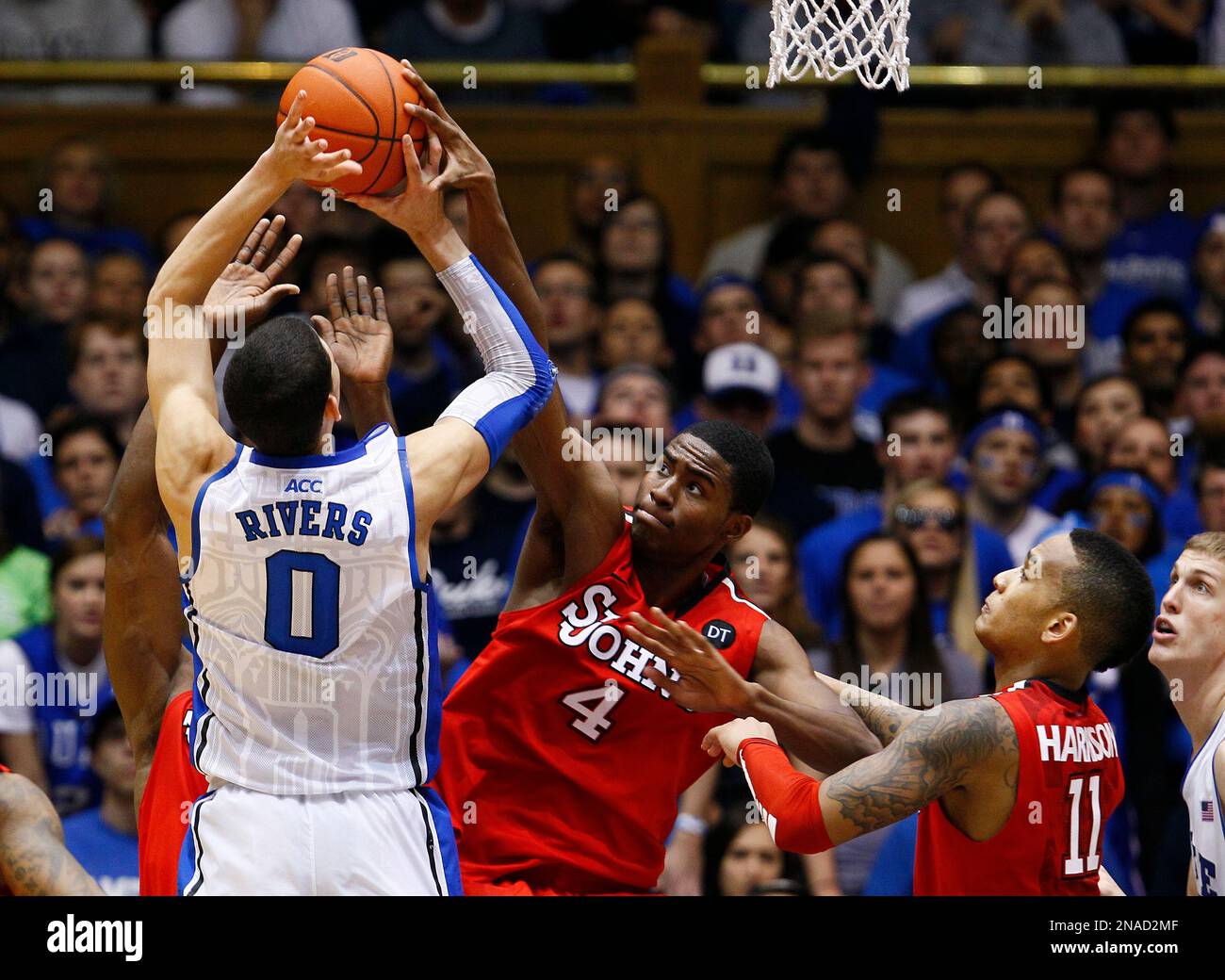 Dukes' Austin Rivers (0) shoots as St. Johns' Moe Harkless (4) and D ...