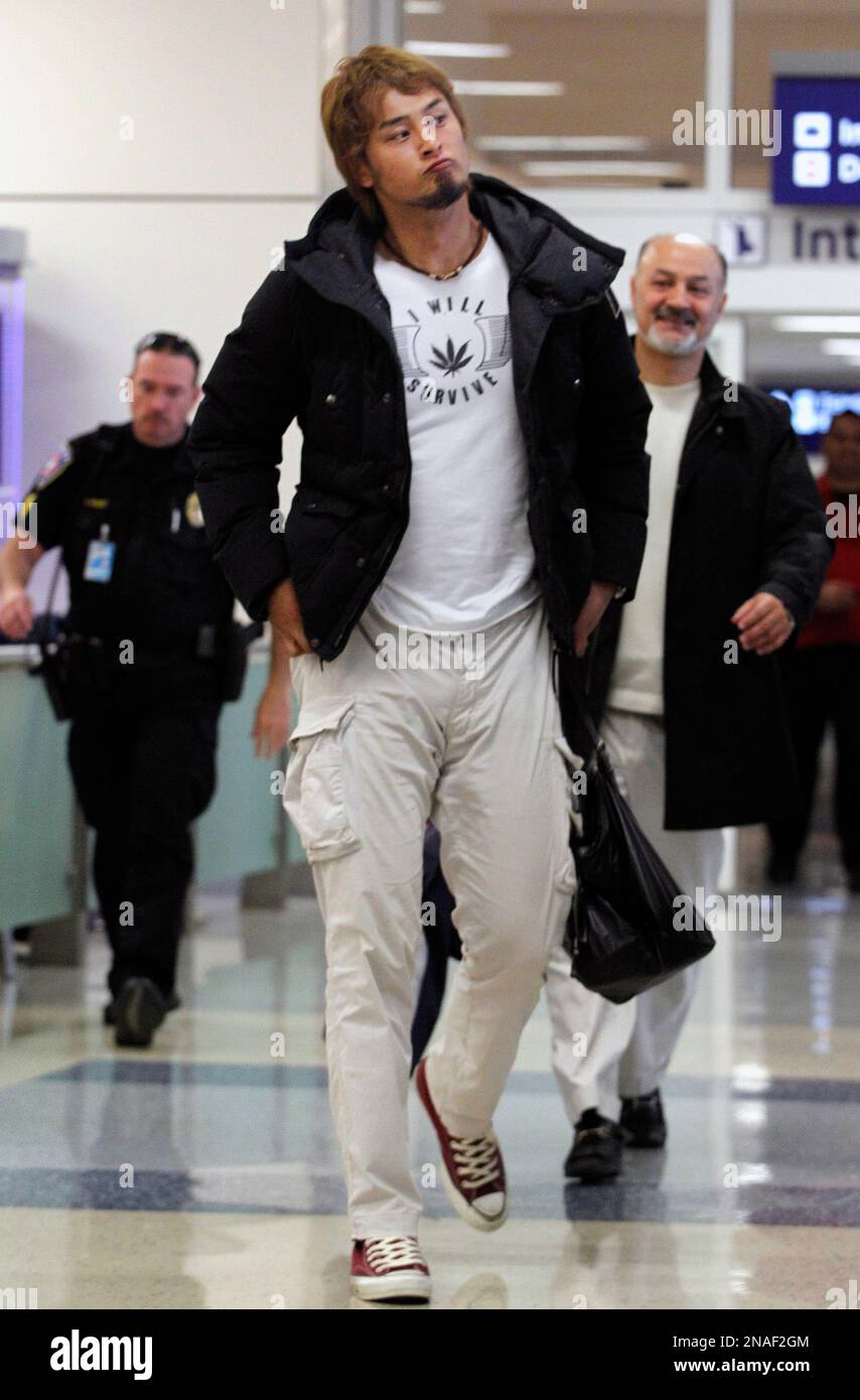 New Texas Rangers pitcher Yu Darvish walks through the terminal after ...
