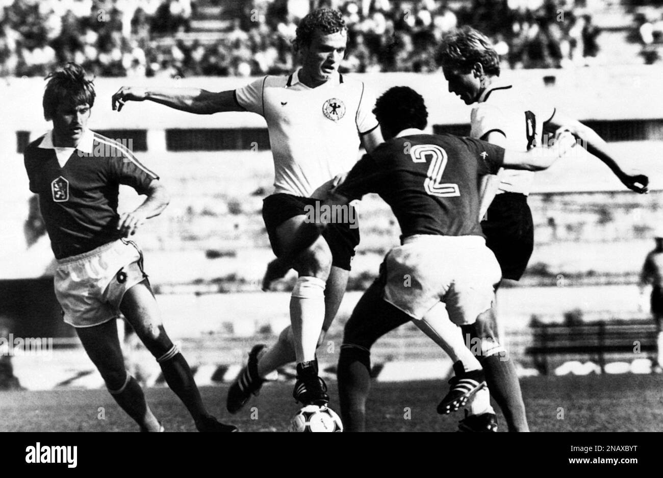 West Germany's Hans-Peter Briegel, centre, and team-mate Karl-Heinz ...