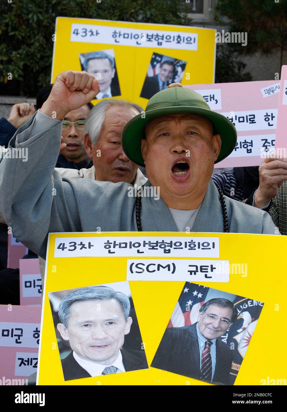 A monk shouts slogan as he holds pictures of U.S. Defense Secretary ...