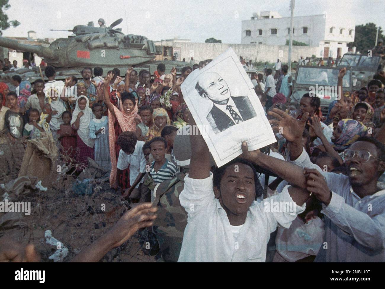 Somalis crowding around an Italian armored personnel carrier, one hold ...