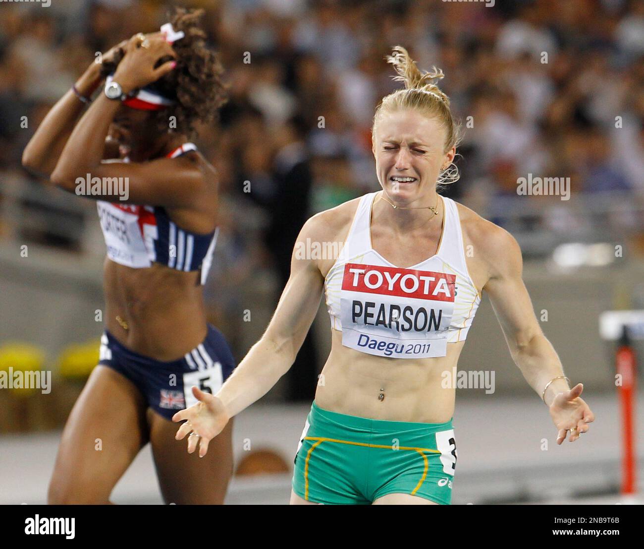 Australia's Sally Pearson, right, reacts as she crosses the finish line ...