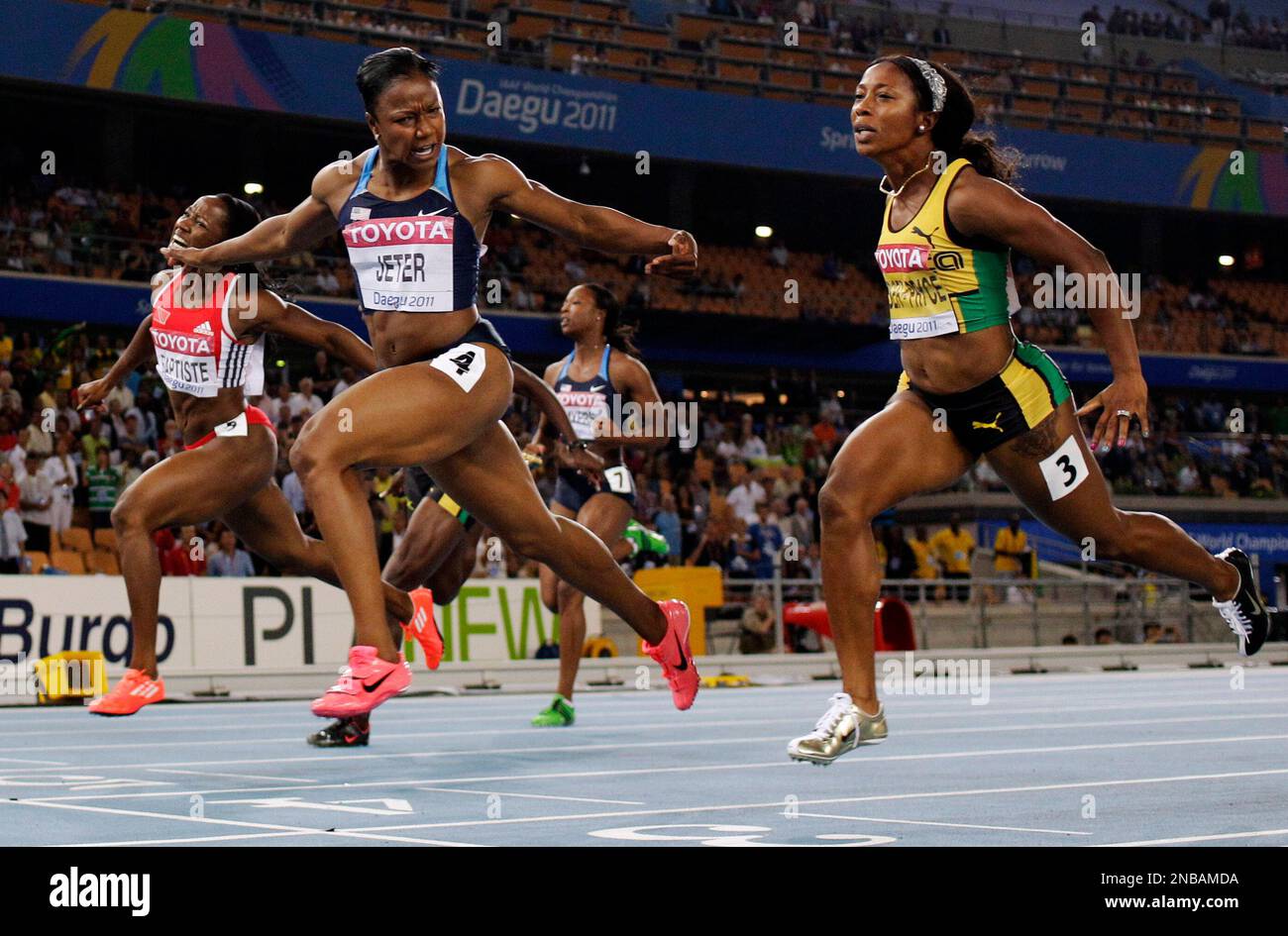 USA's Carmelita Jeter, center, crosses the finish line ahead of ...