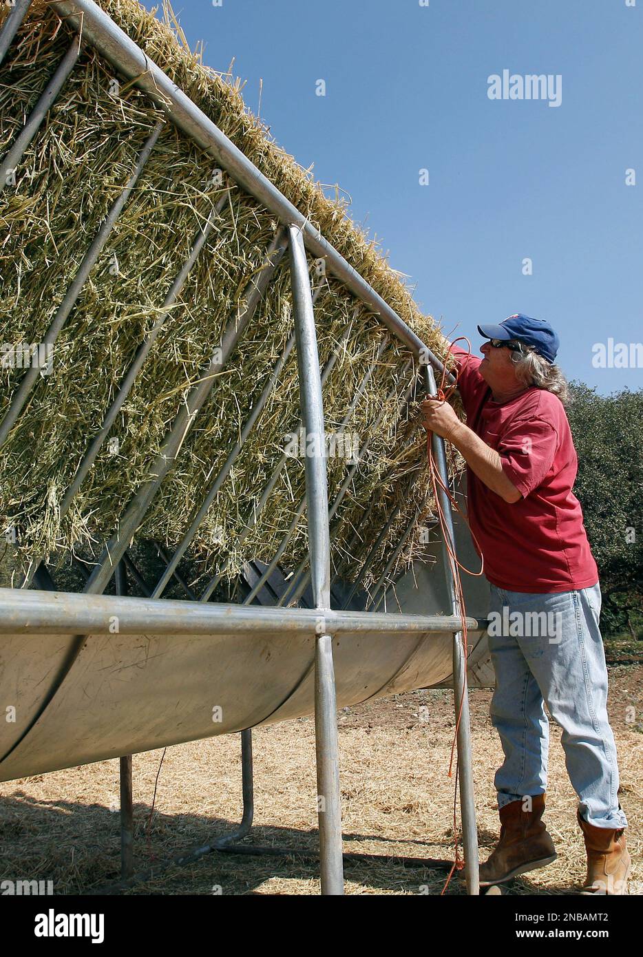 In this Aug. 25, 2011 photo, rancher Don Davis prepares a bail of feed ...
