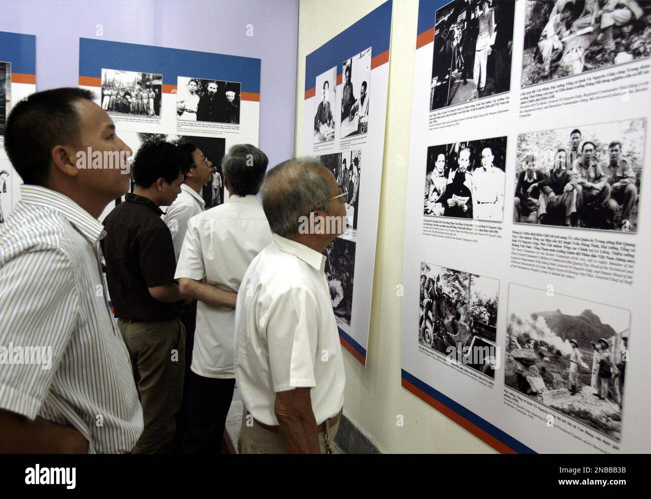 Vietnamese men look at photos of Gen. Vo Nguyen Giap at a photo ...