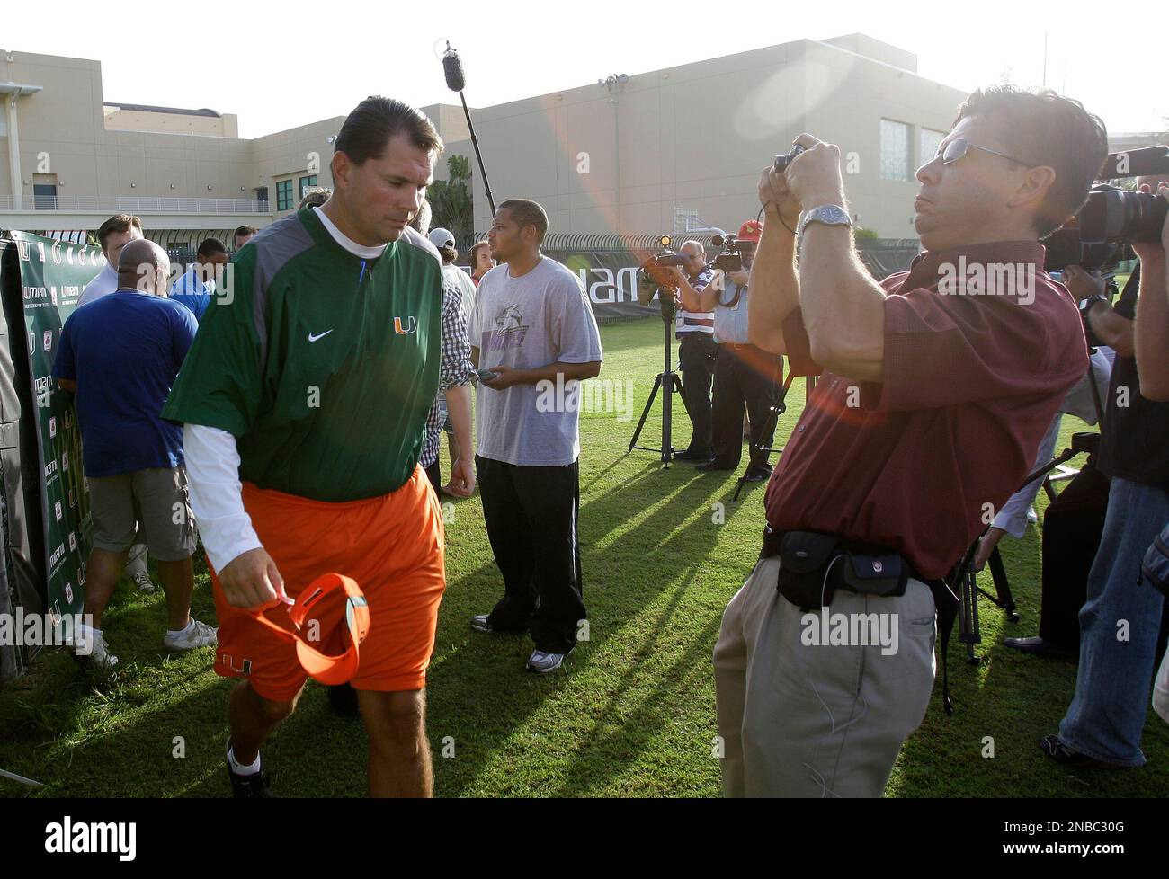Miami's head football coach Al Golden, left, leaves a news conference ...