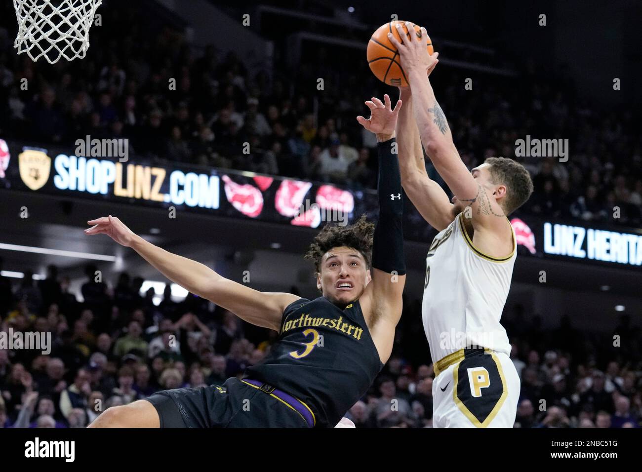 Northwestern guard Ty Berry, left, battles for a rebound against Purdue ...