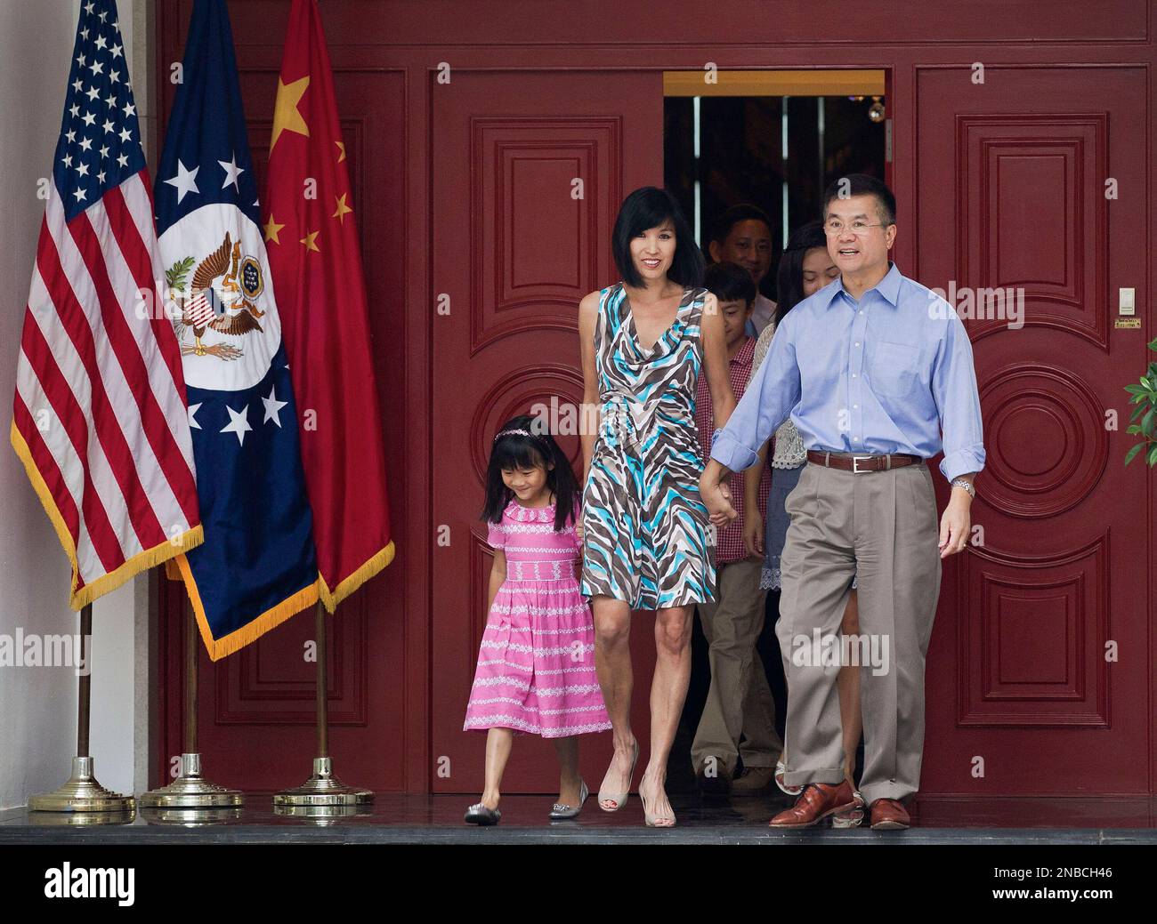 U.S. Ambassador to China Gary Locke walks out from a door with his wife Mona Lee and his ...