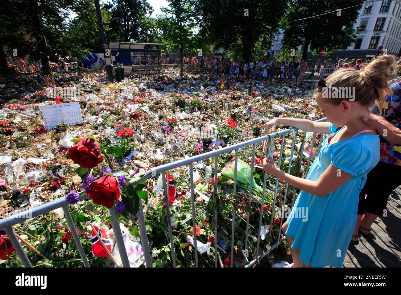 People are seen around thousands of flowers and tributes laid outside ...