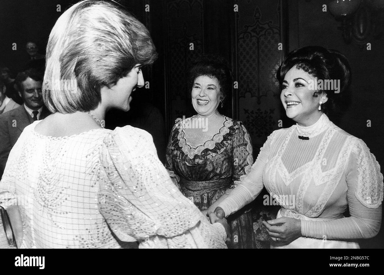 Britain’s Princess of Wales, Diana, left, shakes hands with a smiling ...
