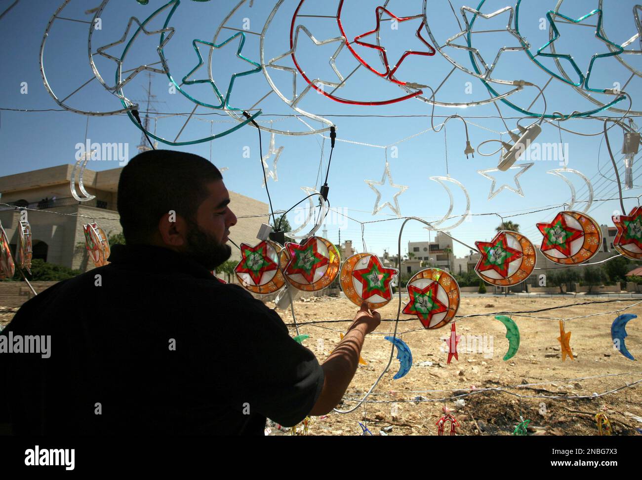 A Jordanian street vendor seen with Ramadan decorations, neon lights of ...